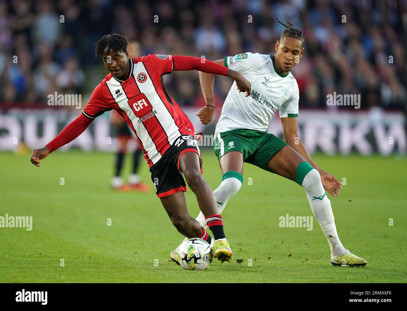 Sheffield United's Andre Brooks (left) and Lincoln City's Alistair Smith battle for the ball ...