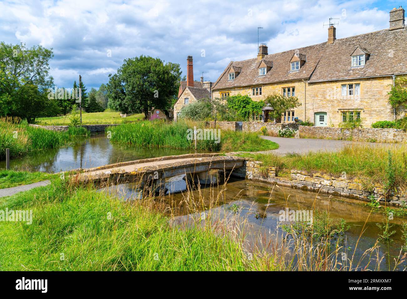 A small pedestrian bridge over the River Eye at the idyllic Cotswold ...
