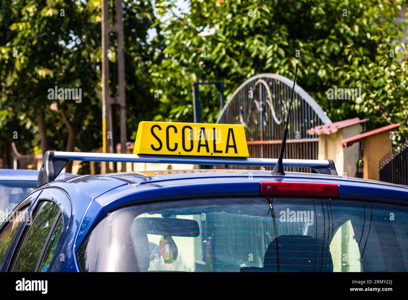 Driving school sign placed on top of car Stock Photo - Alamy