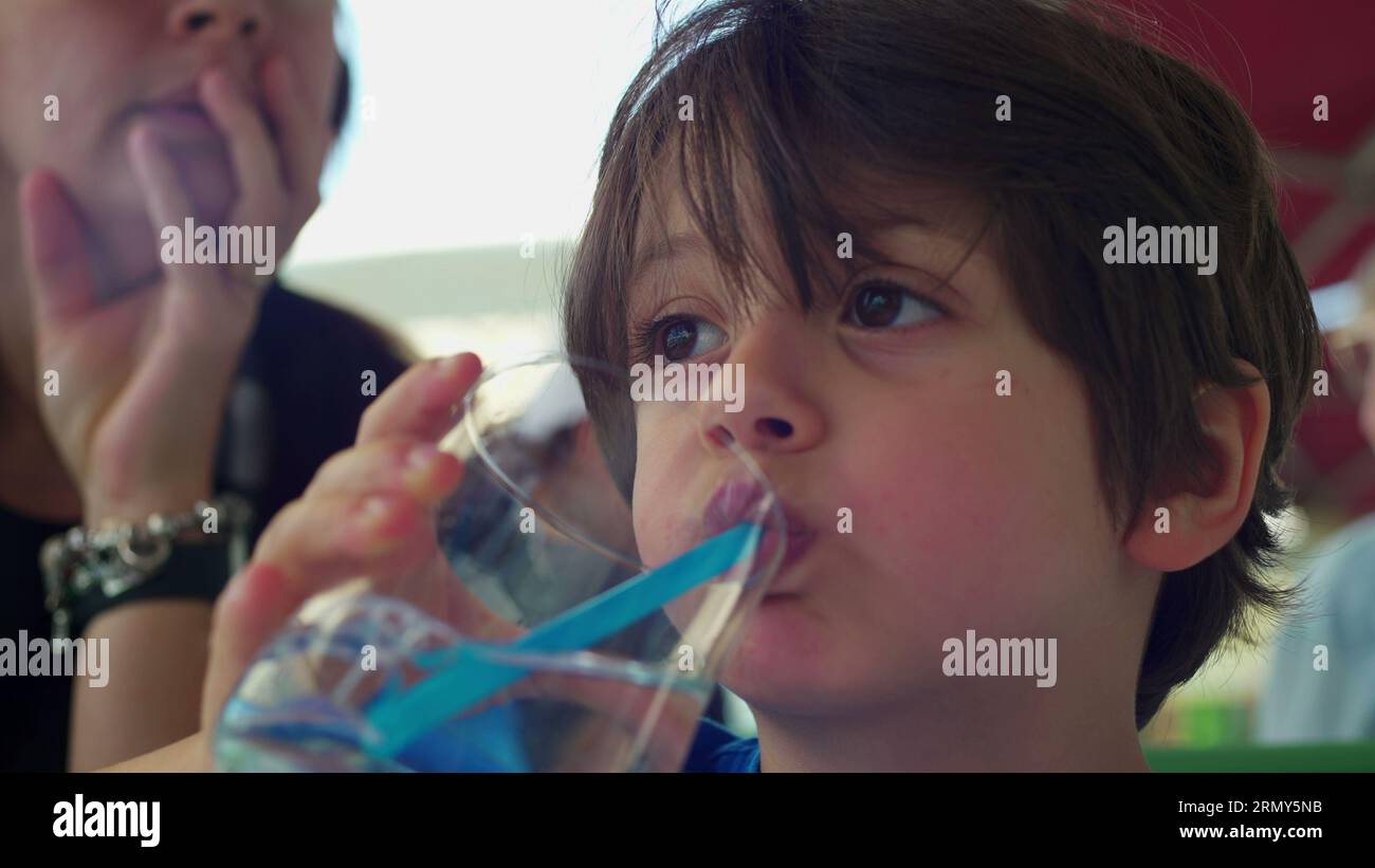 Small Boy Hydrating Himself with Water and Straw at Restaurant, Close-Up Face During Hot Summer ...