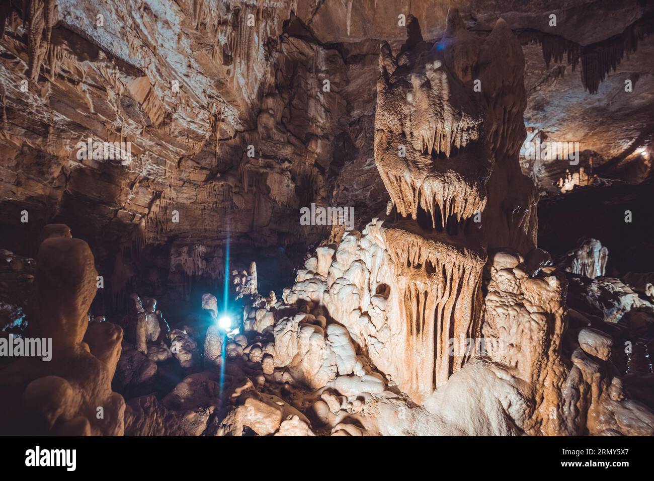 Big underground hall in a cave filled with stalactites and stalagmites ...