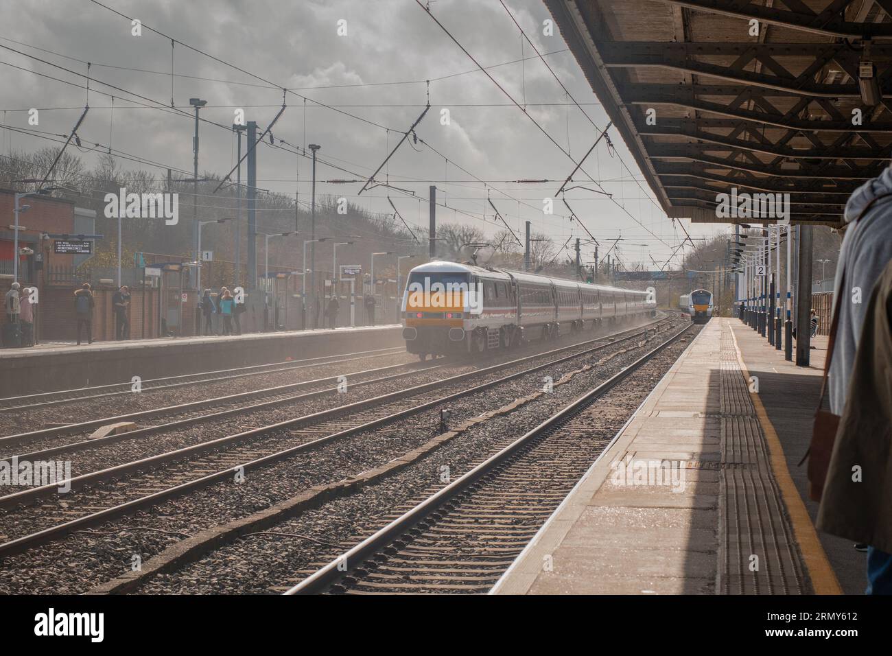 Fast and a conventional train on a Hitchin train station in england ...