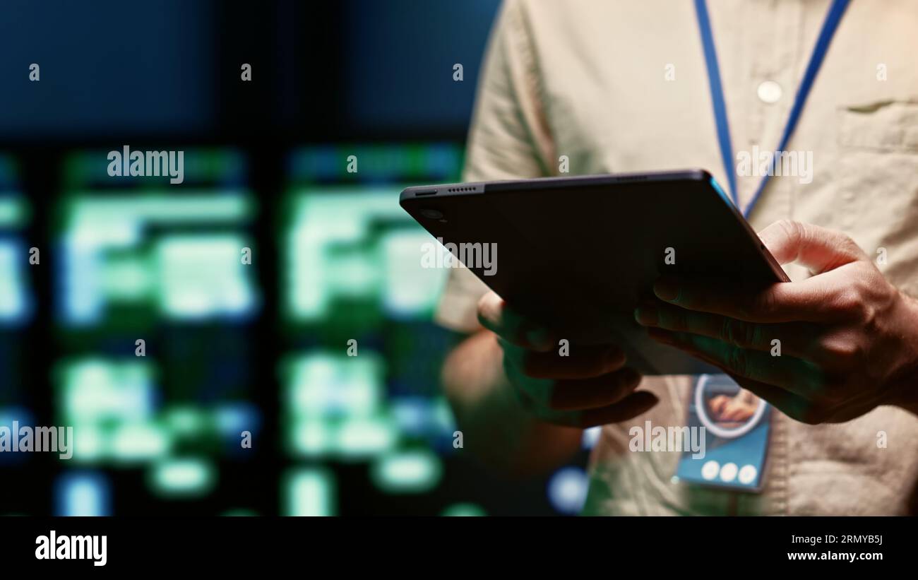 Serviceman verifying maintenance checklist in high tech facility ...