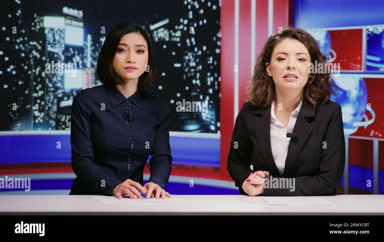Diverse journalists host night show live on tv network, presenting breaking news segment in ...