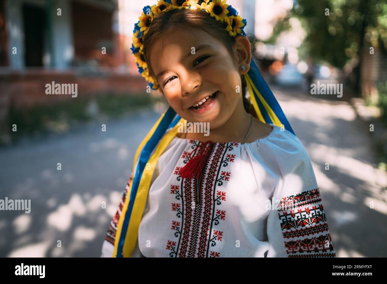 Child girl in Ukrainian traditional clothes and flower wreath is ...