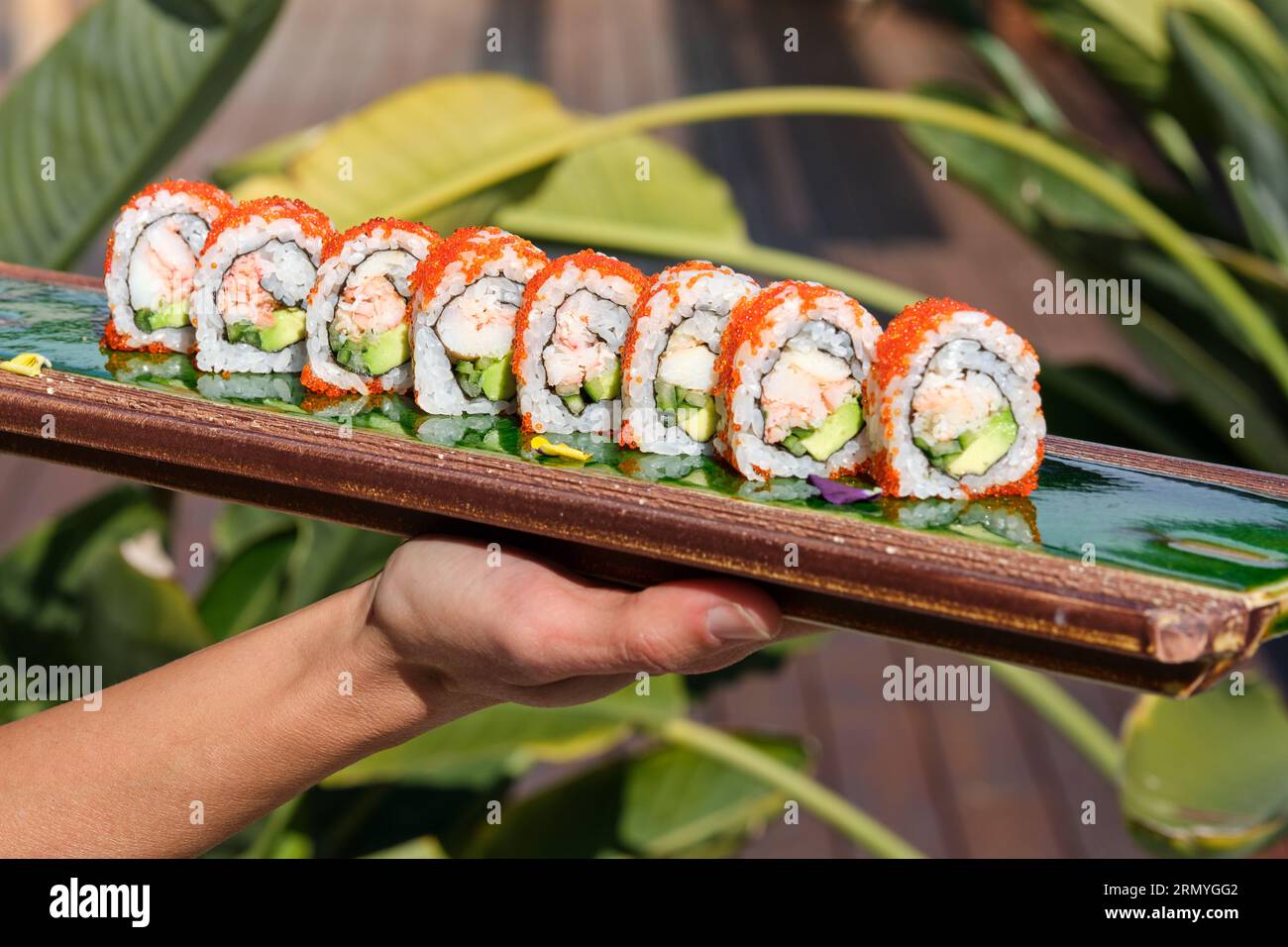 Crop unrecognizable waitress demonstrating platter with tasty ...