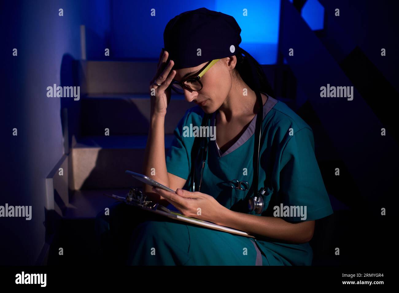 Confused female doctor in medical uniform with stethoscope sitting on ...