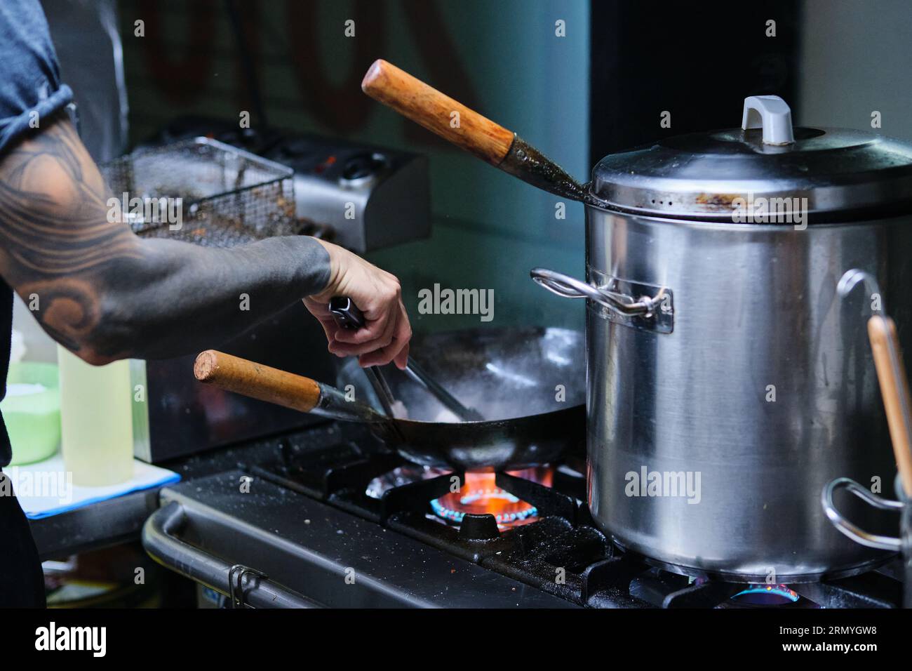 Stock photo of unrecognized chef using saucepan in the kitchen of ...
