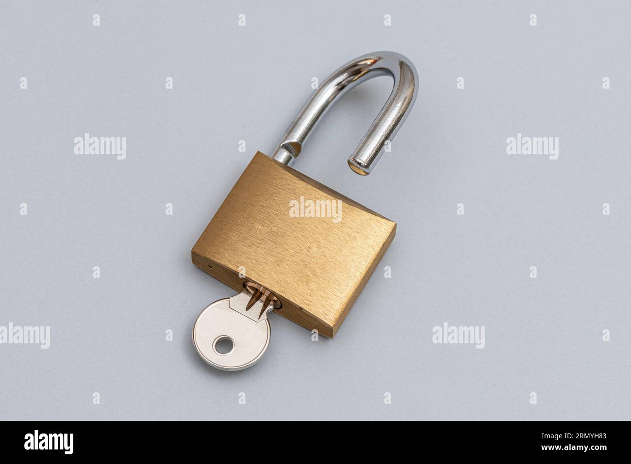 Unlocked golden padlock on the gray background Stock Photo - Alamy