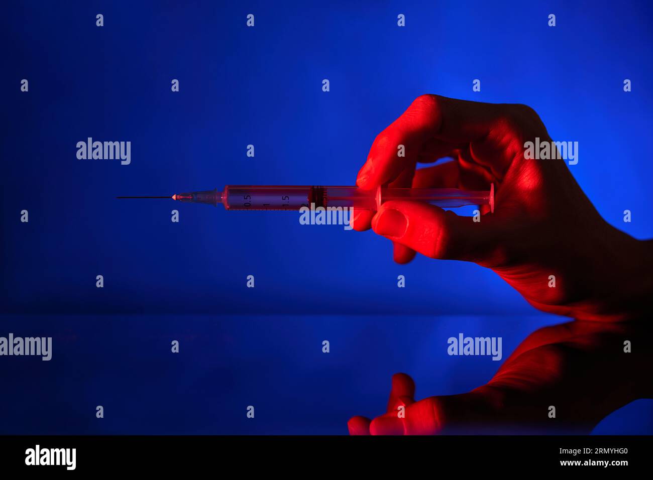 Crop person holding medical syringe with needle filled with COVID 19 ...