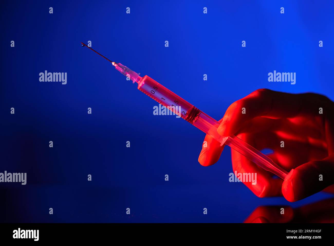 Crop anonymous person holding medical syringe with needle filled with ...