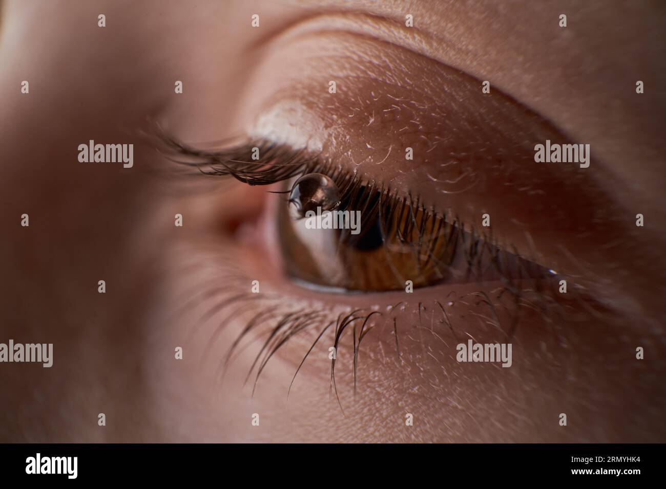 Closeup brown eye of crop unrecognizable depressed kid with small round ...