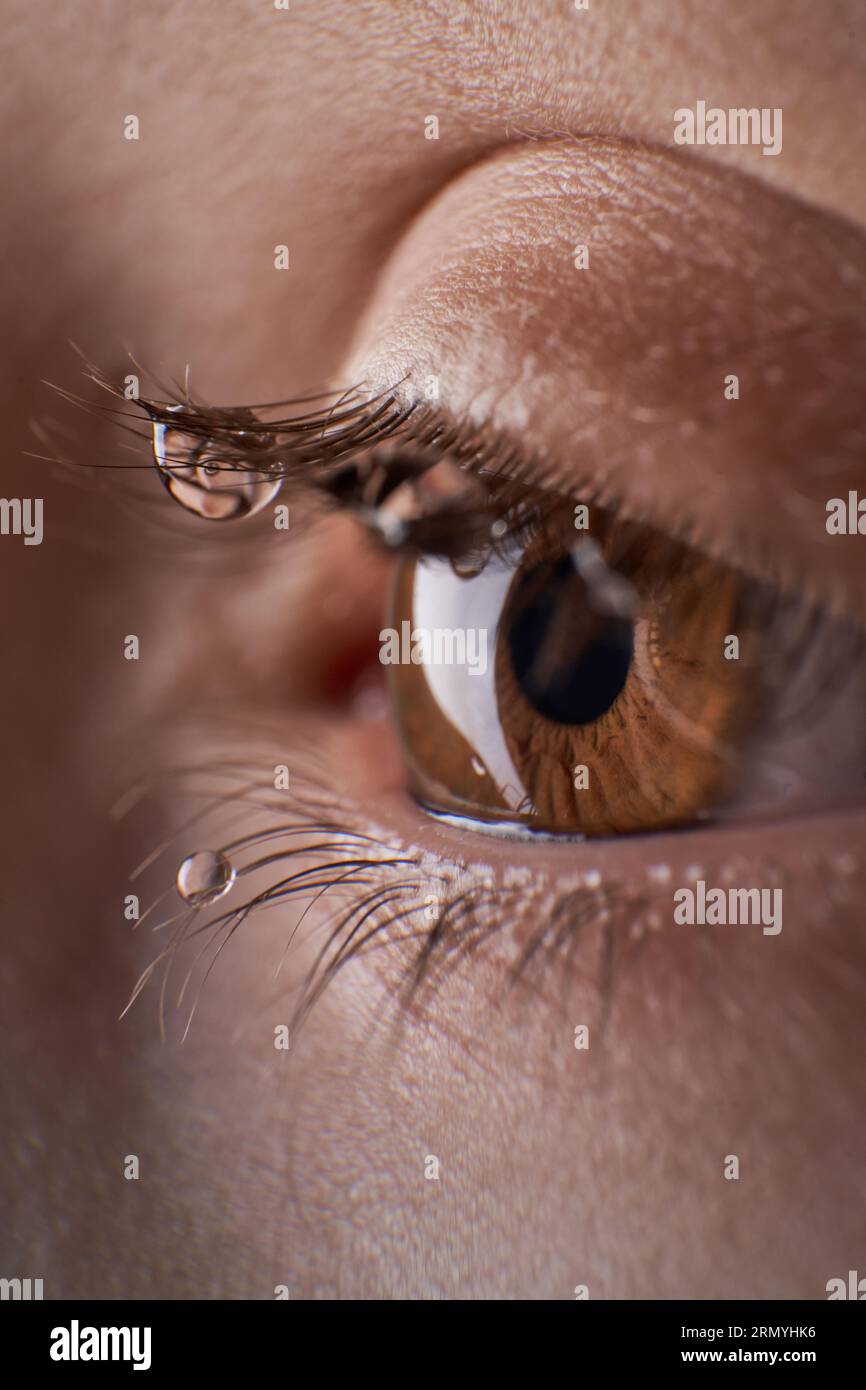 Closeup brown eye of crop unrecognizable sad kid with round small tears ...