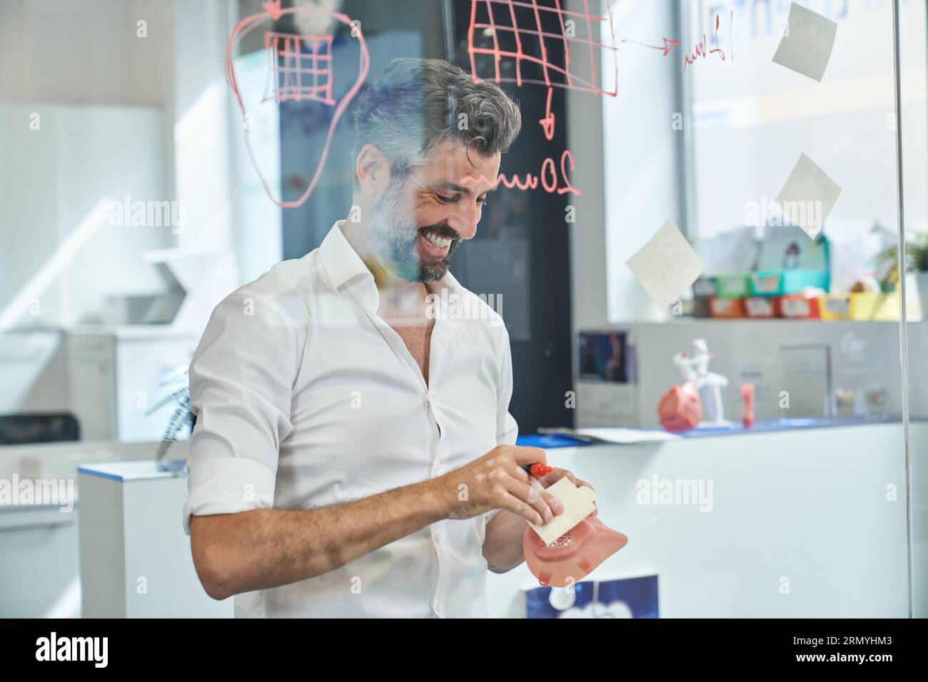 Through window of glad male engineer in formal wear with respirator ...