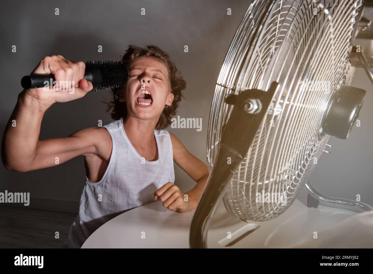 Funny kid screaming into hair brush pretending singing into microphone ...