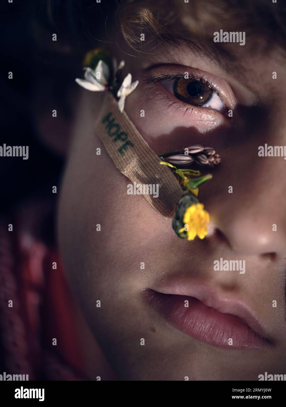 Crop face of kid with tiny flowers clued by tape looking at camera on ...
