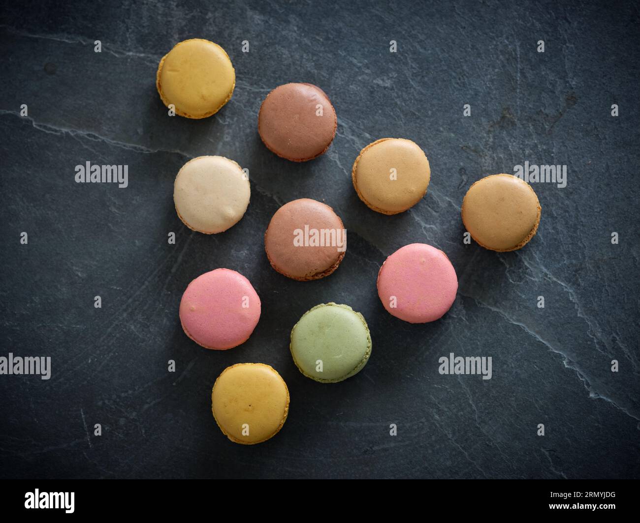 Top view set of sweet macaroons with different flavors placed on gray ...