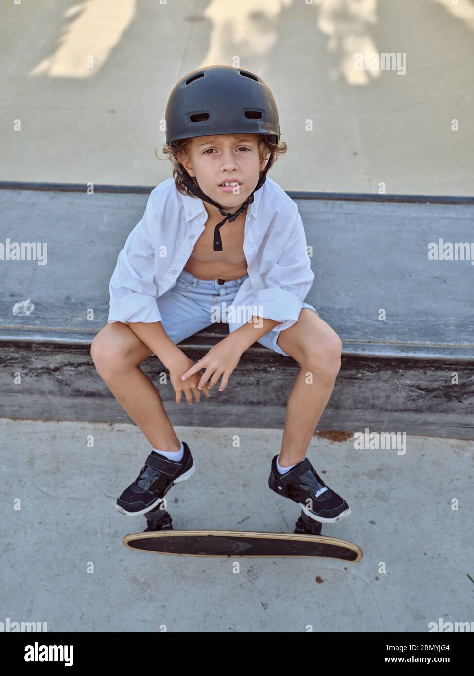 High angle full length of young skater in helmet with longboard looking ...
