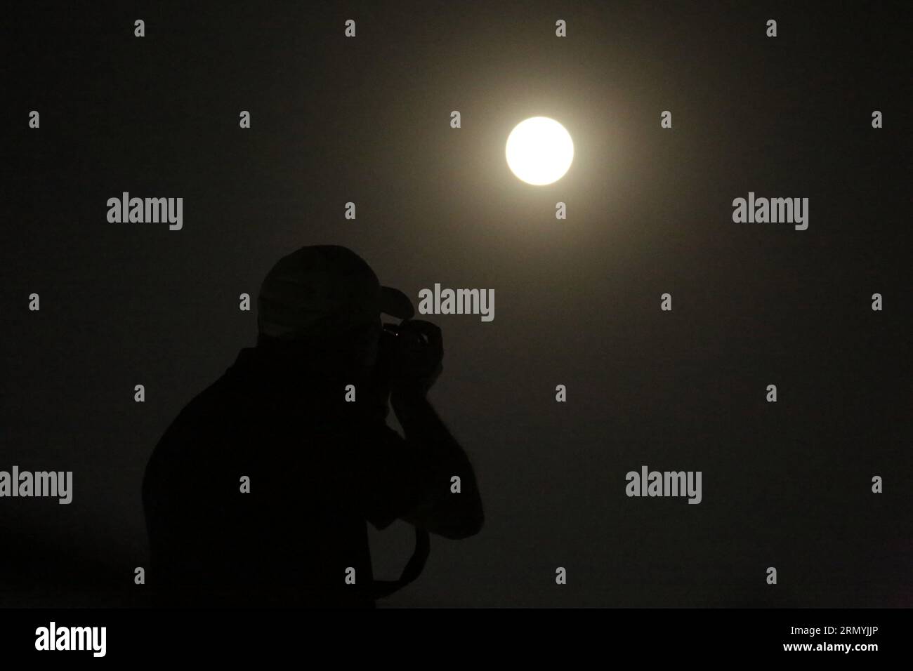 Baghdad, Iraq. 30th Aug, 2023. A man takes a photo of a full moon in ...