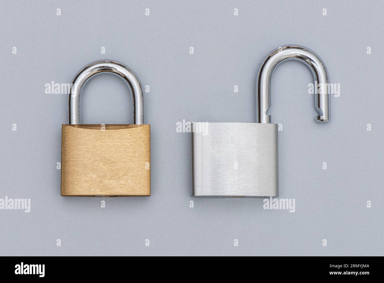 Locked golden and unlocked silver padlock on the gray background Stock ...