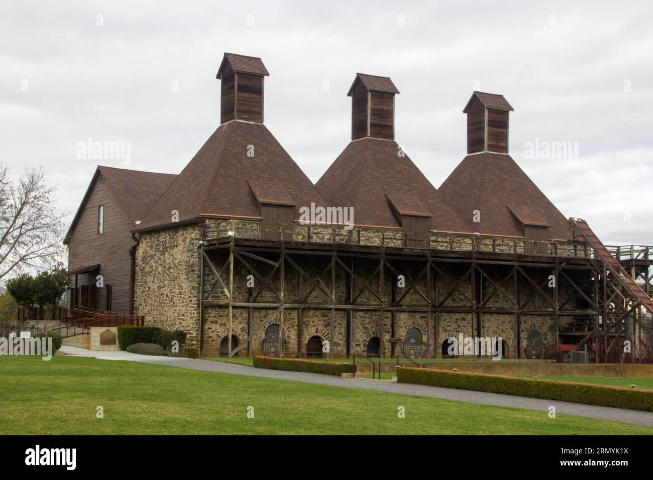 An old decrepit brown brick warehouse and barn has three chimneys. The ...