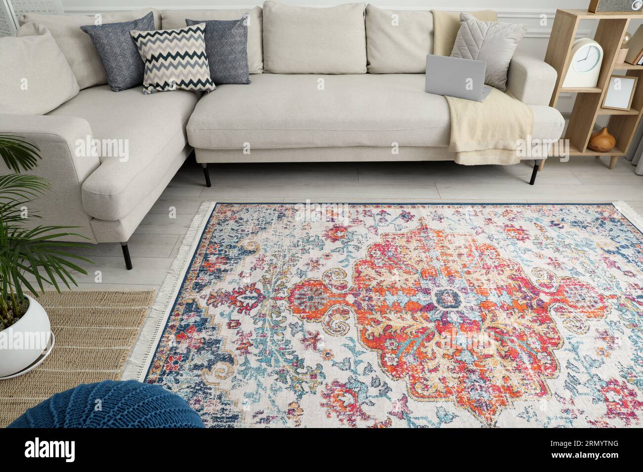 Stylish living room with beautiful carpet, comfortable sofa and laptop ...