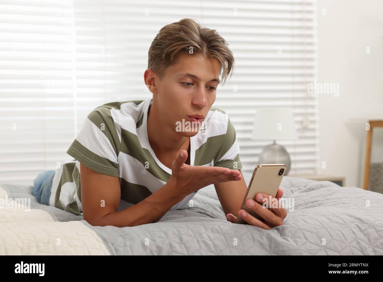 Happy young man having video chat via smartphone and blowing kiss on ...