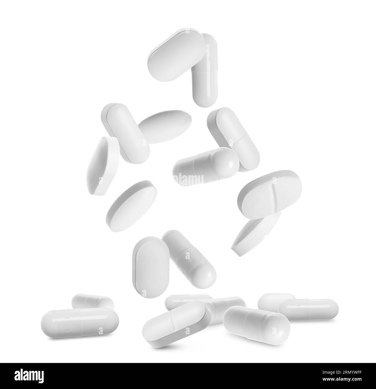 Many different pills falling on white background Stock Photo - Alamy