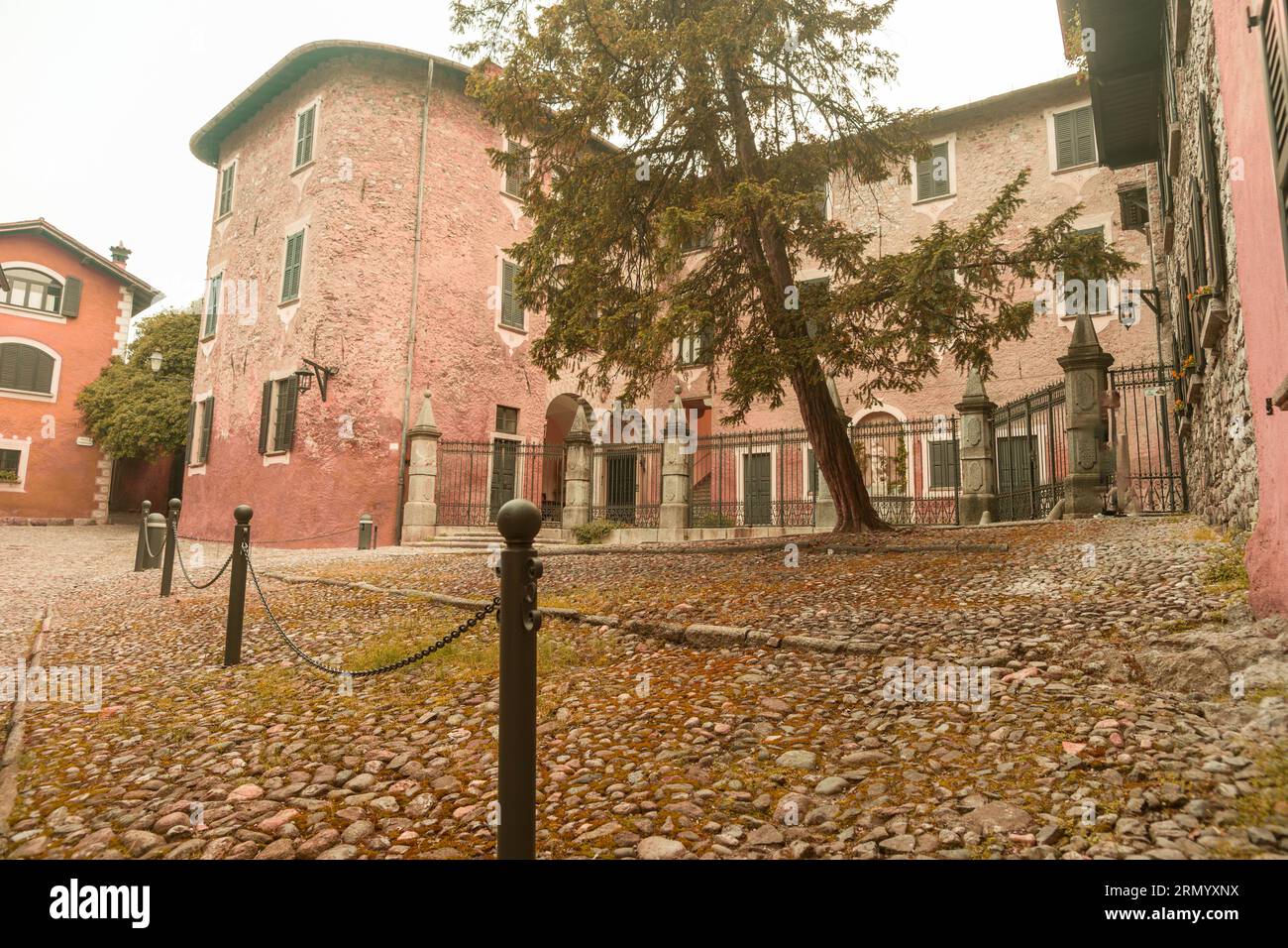 Traditional buildings on stony ground with fence, bollards and-chain ...