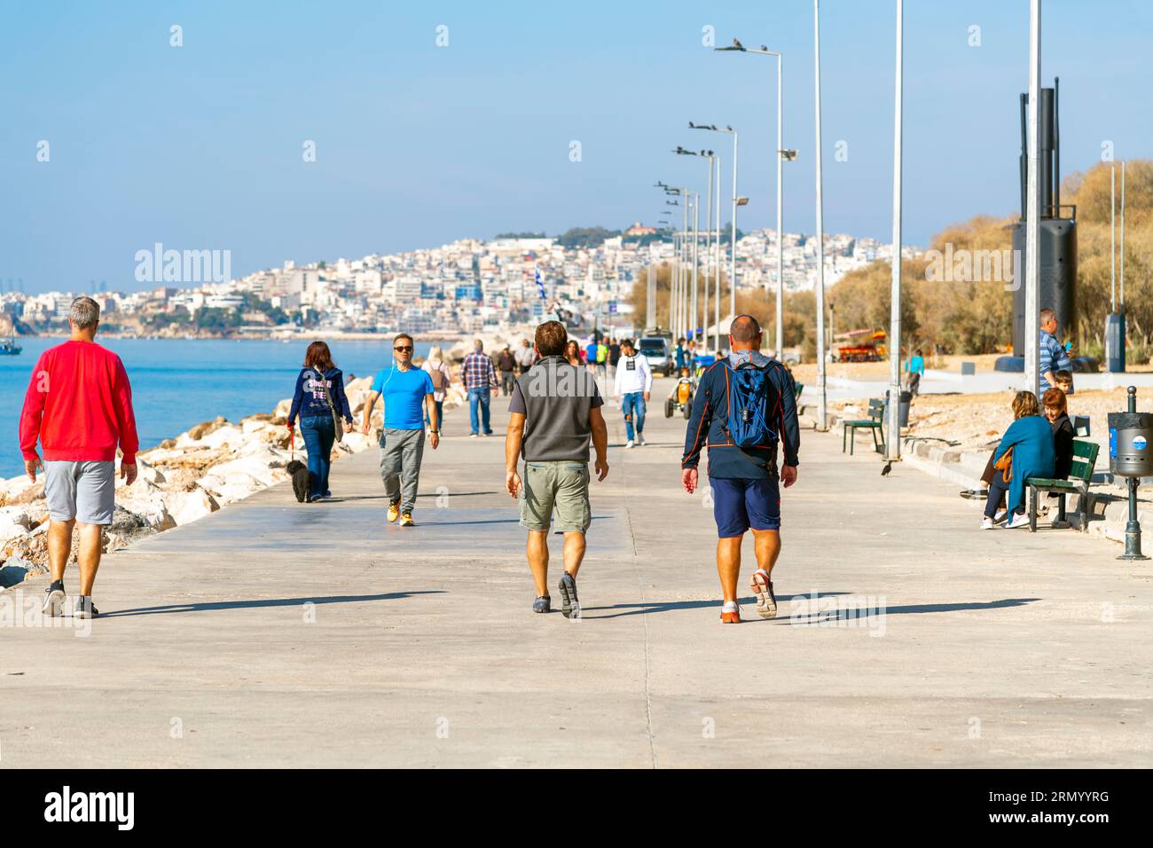 Locals and visitors enjoy a morning walk along the beachfront coastal ...
