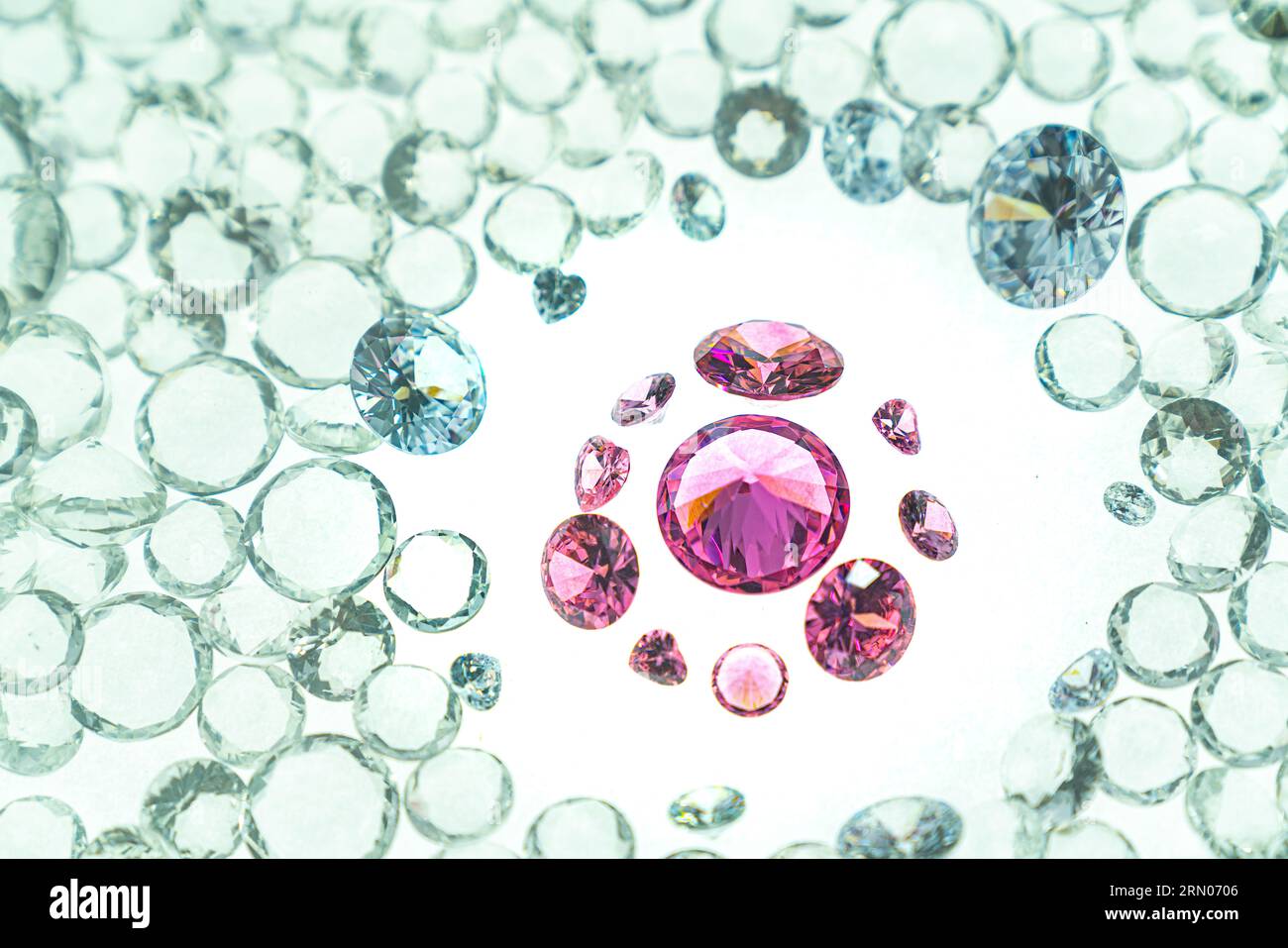 Pink gemstones is displayed on a white background swirling around. Pink ...