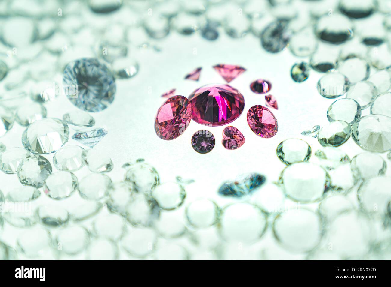 Pink gemstones is displayed on a white background swirling around. Pink ...