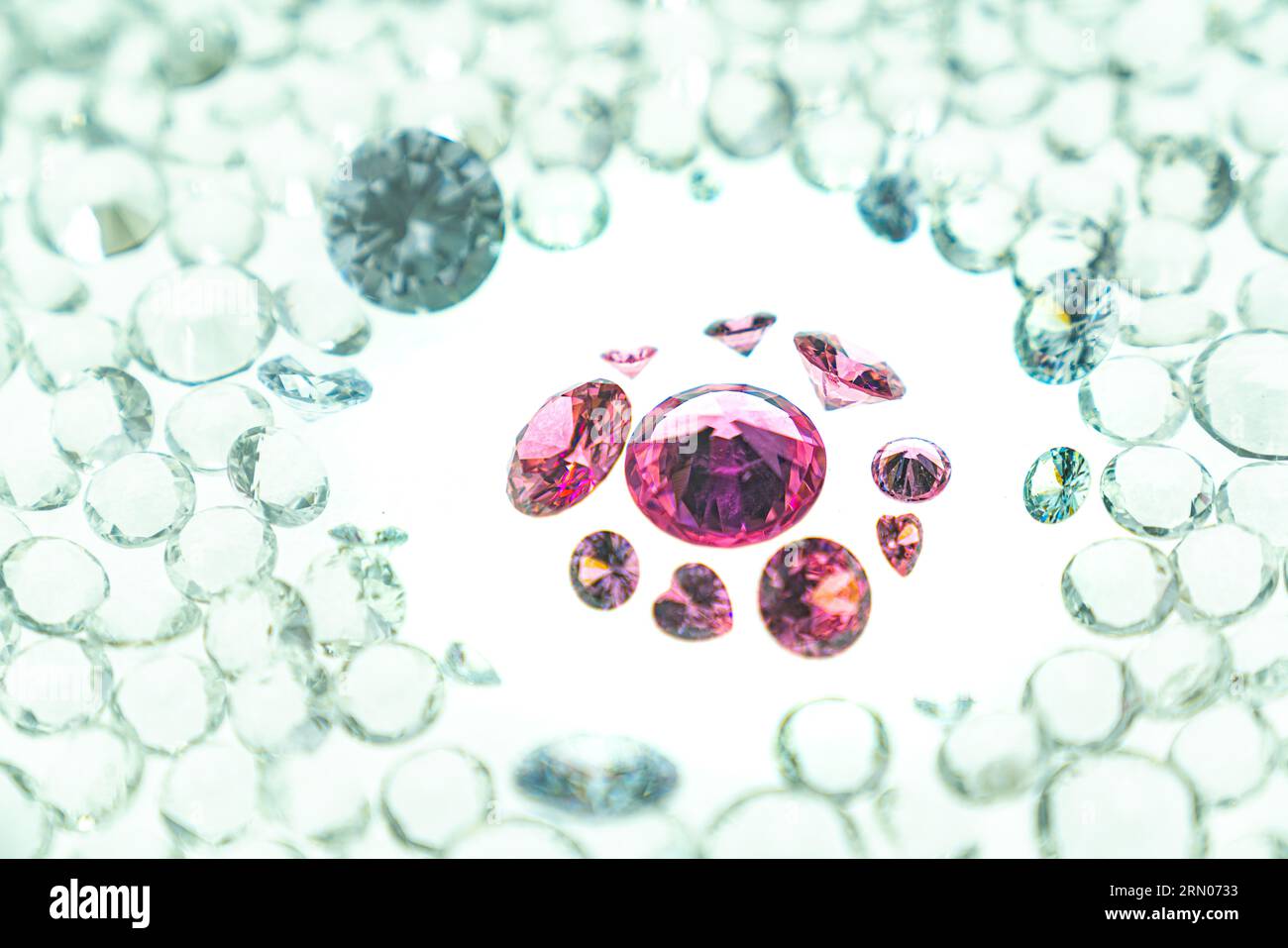 Pink gemstones is displayed on a white background swirling around. Pink ...