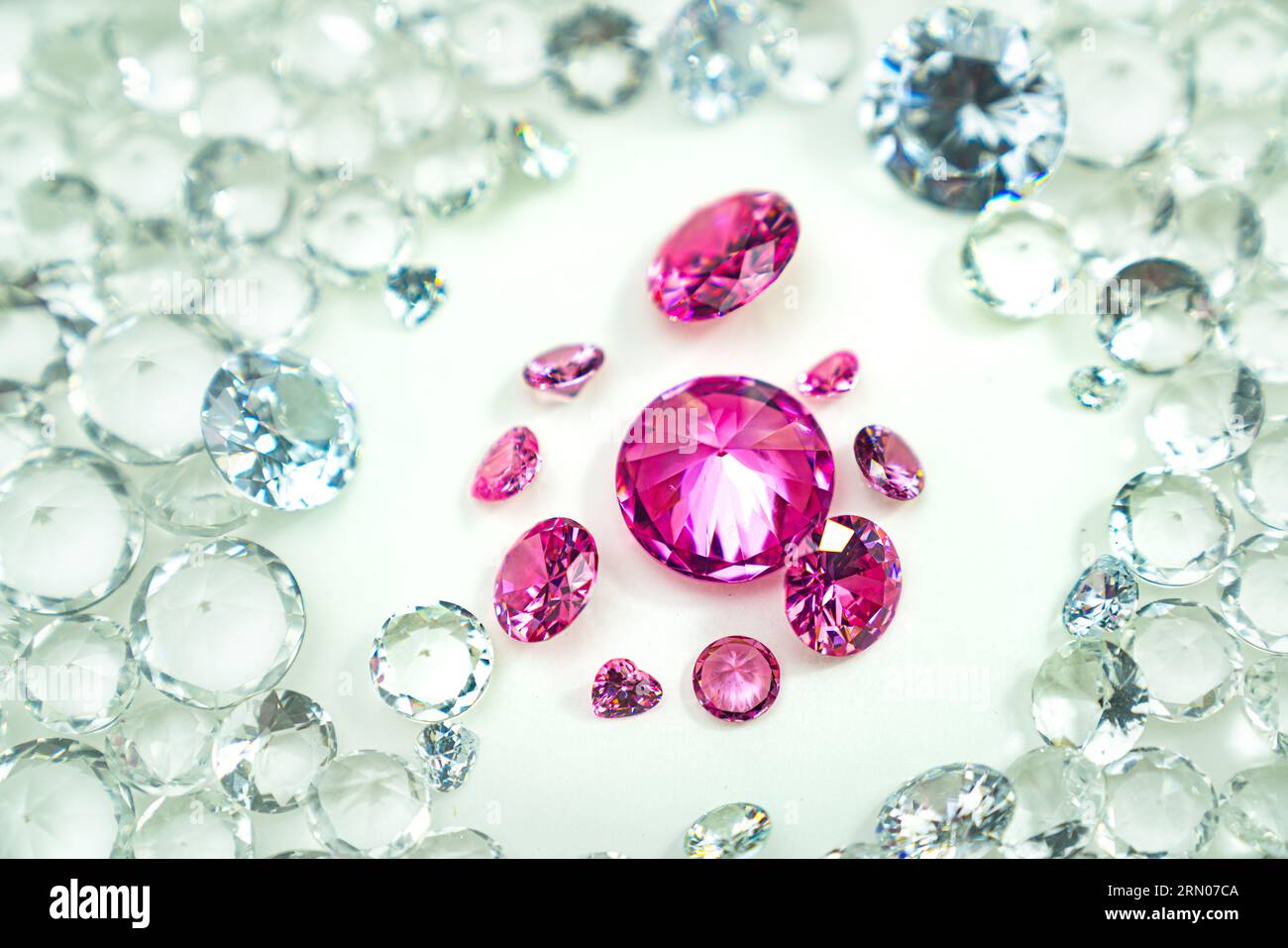 Pink gemstones is displayed on a white background swirling around. Pink ...