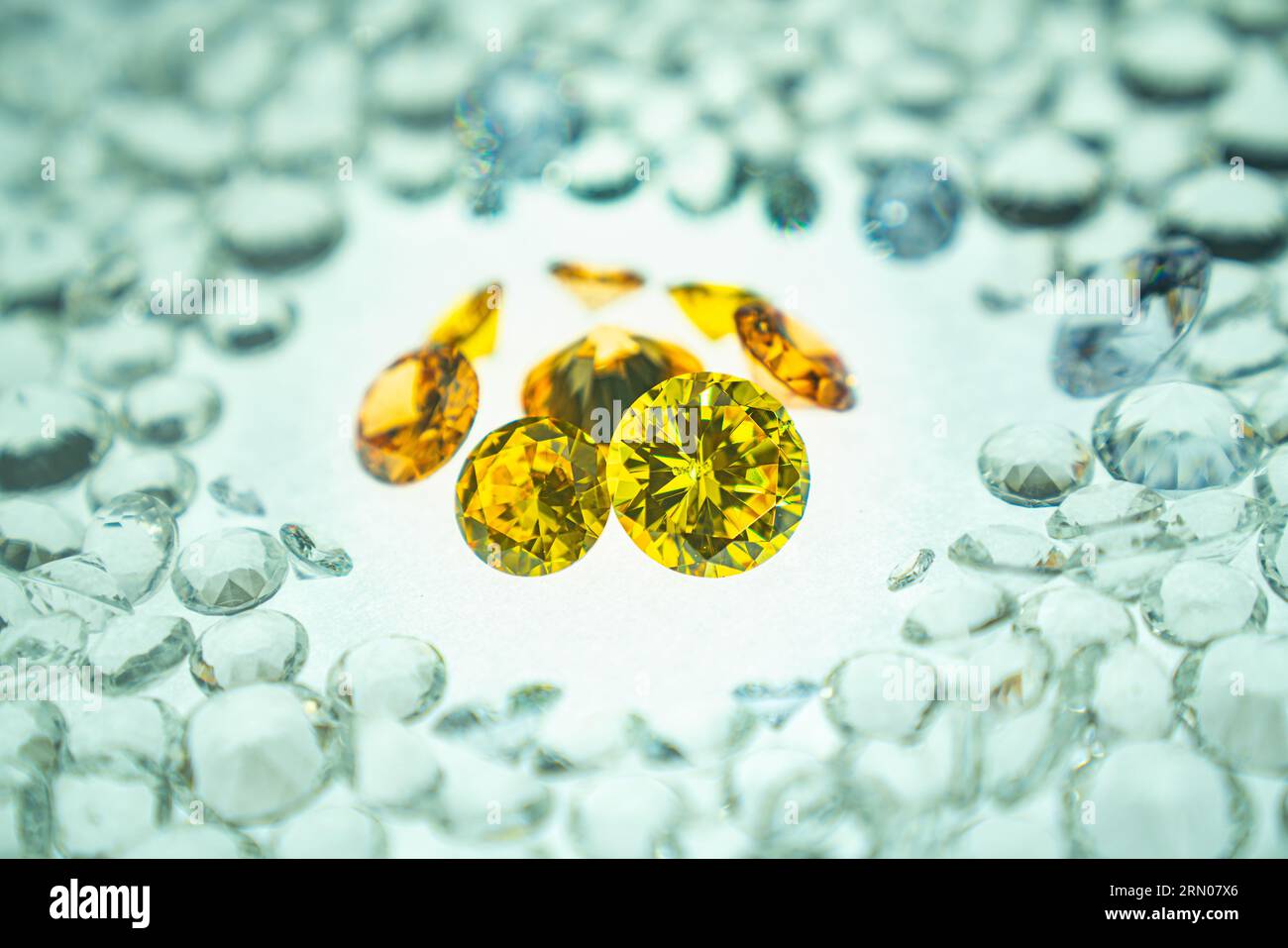 Yellow gemstones is displayed on a white background swirling around ...