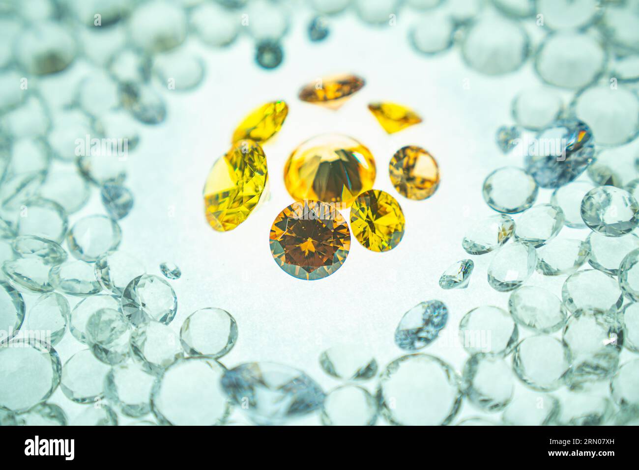 Yellow gemstones is displayed on a white background swirling around ...