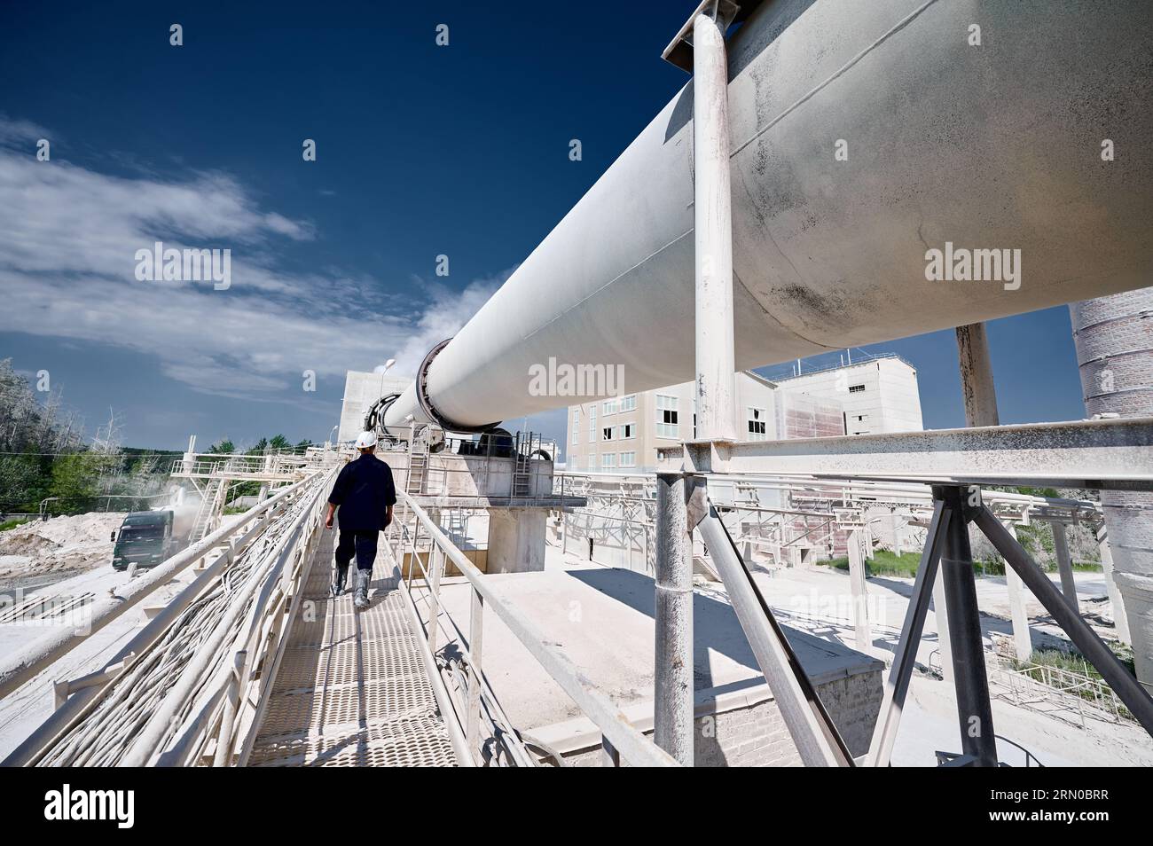 Worker walks along ladders for maintenance of rotary kiln Stock Photo ...