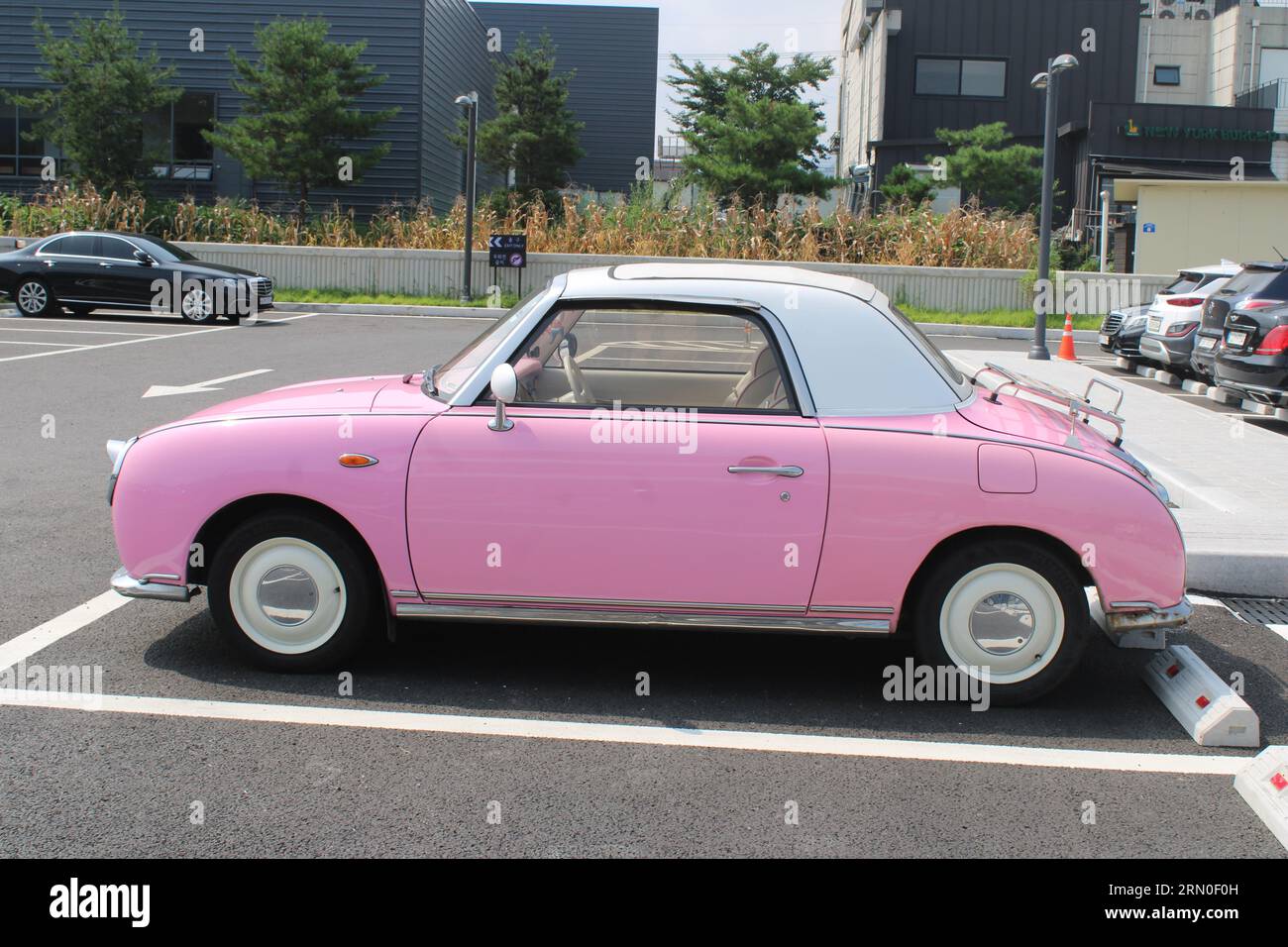 Side view of vintage pink car in parking lot Stock Photo - Alamy