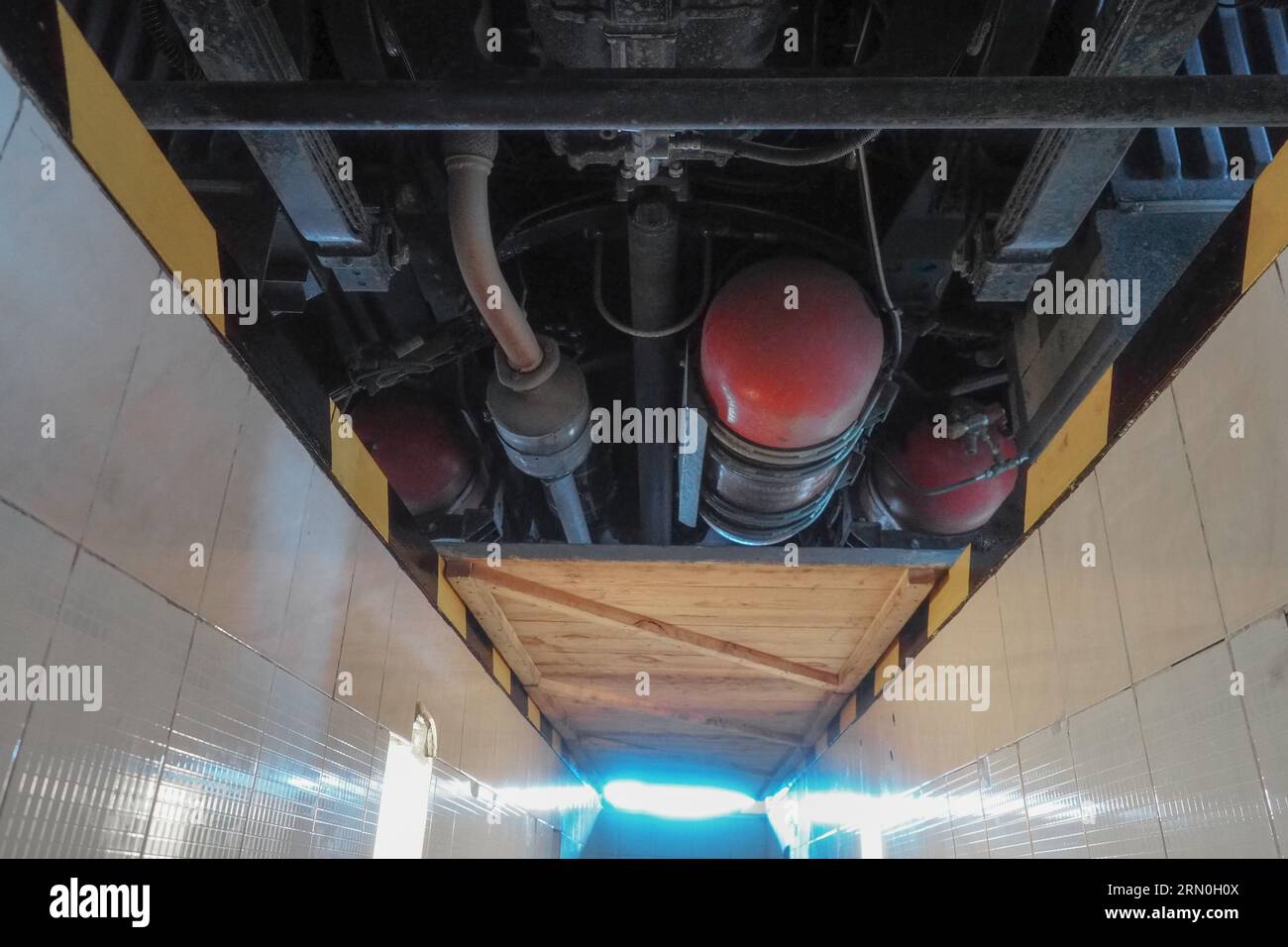 View of bottom of car with gas cylinder from repair pit of car service ...