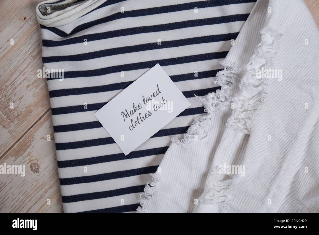 MAKE LOVED CLOTHES LAST text on paper note on clothes assortment Second ...