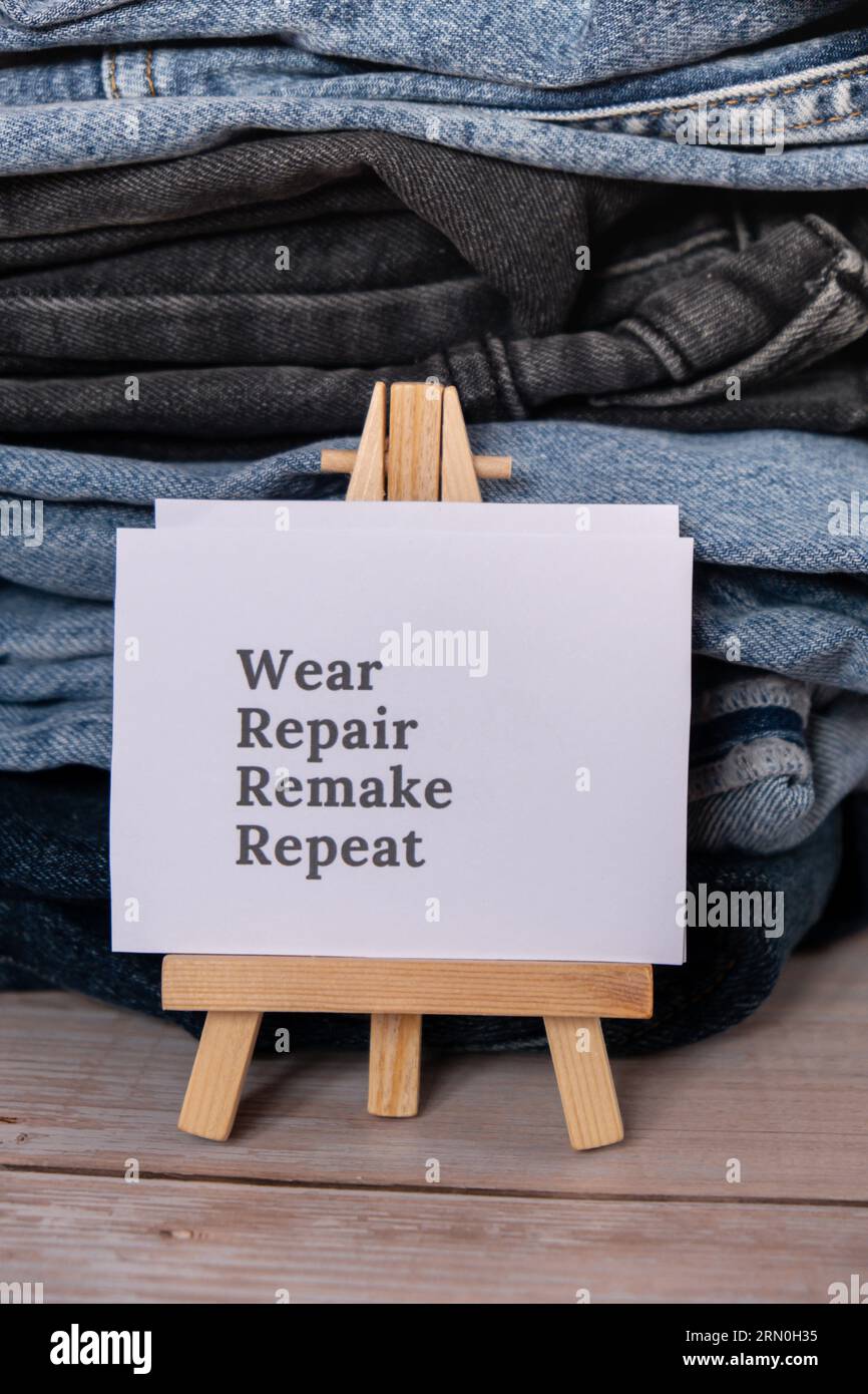 WEAR REPAIR REMAKE REPEAT text on paper note on Jeans clothes ...