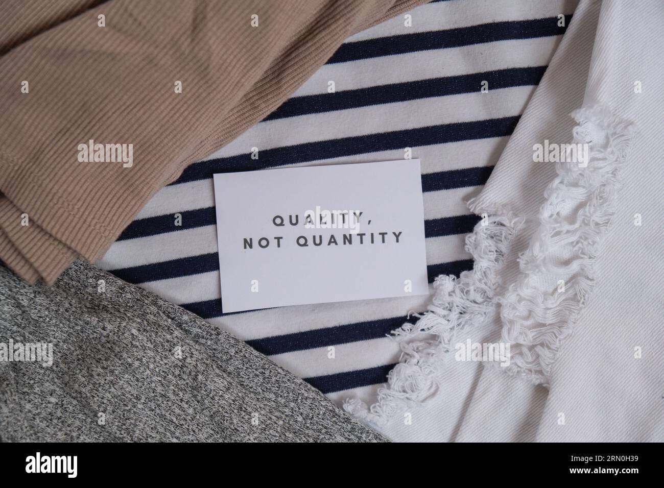 Quality not quantity text on paper note on clothes assortment Second ...