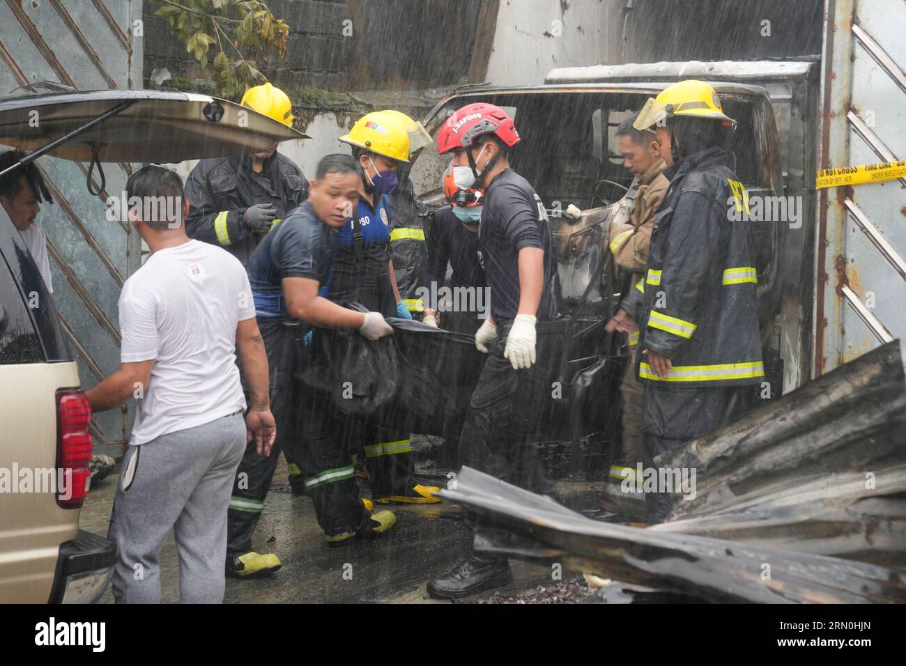 Firemen carry body bag of a victim of a fire in Quezon city ...