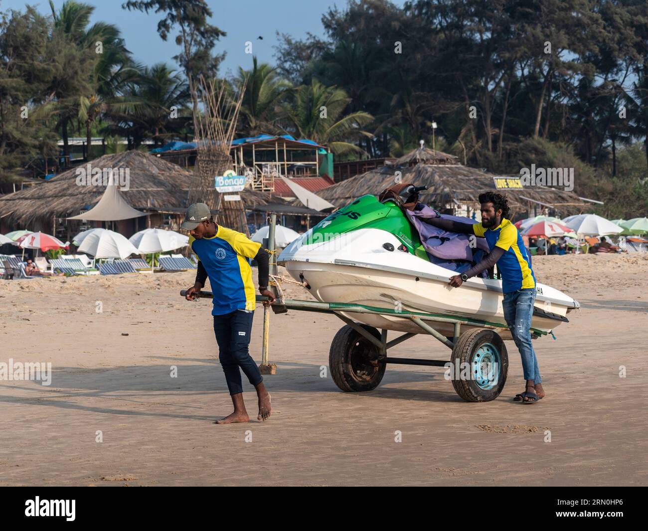Calangute, Goa, India - January 2023: Two men hauling a boat on a cart ...