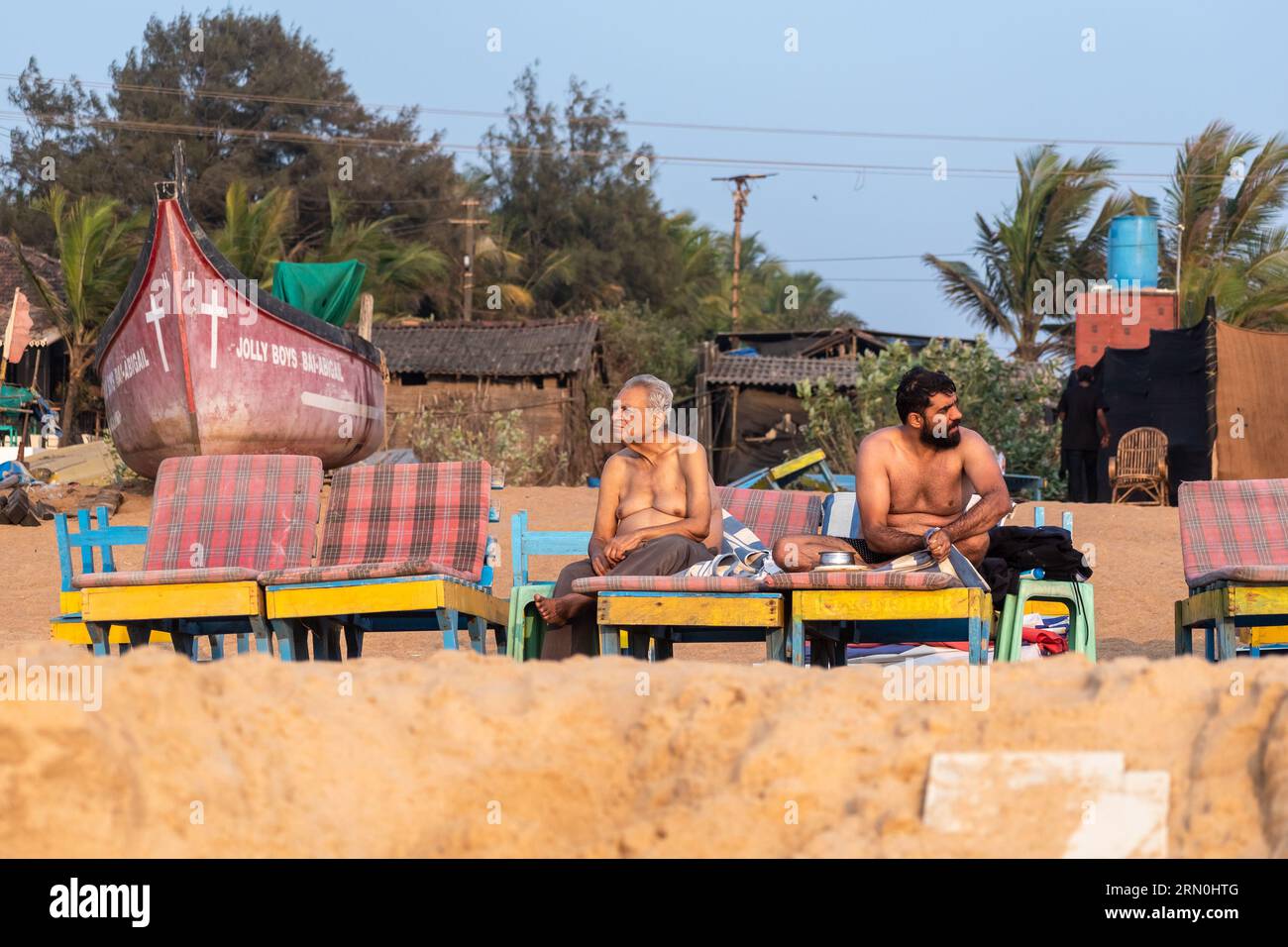 Calangute, Goa, India - January 2023: Two Indian men getting a tan on a ...
