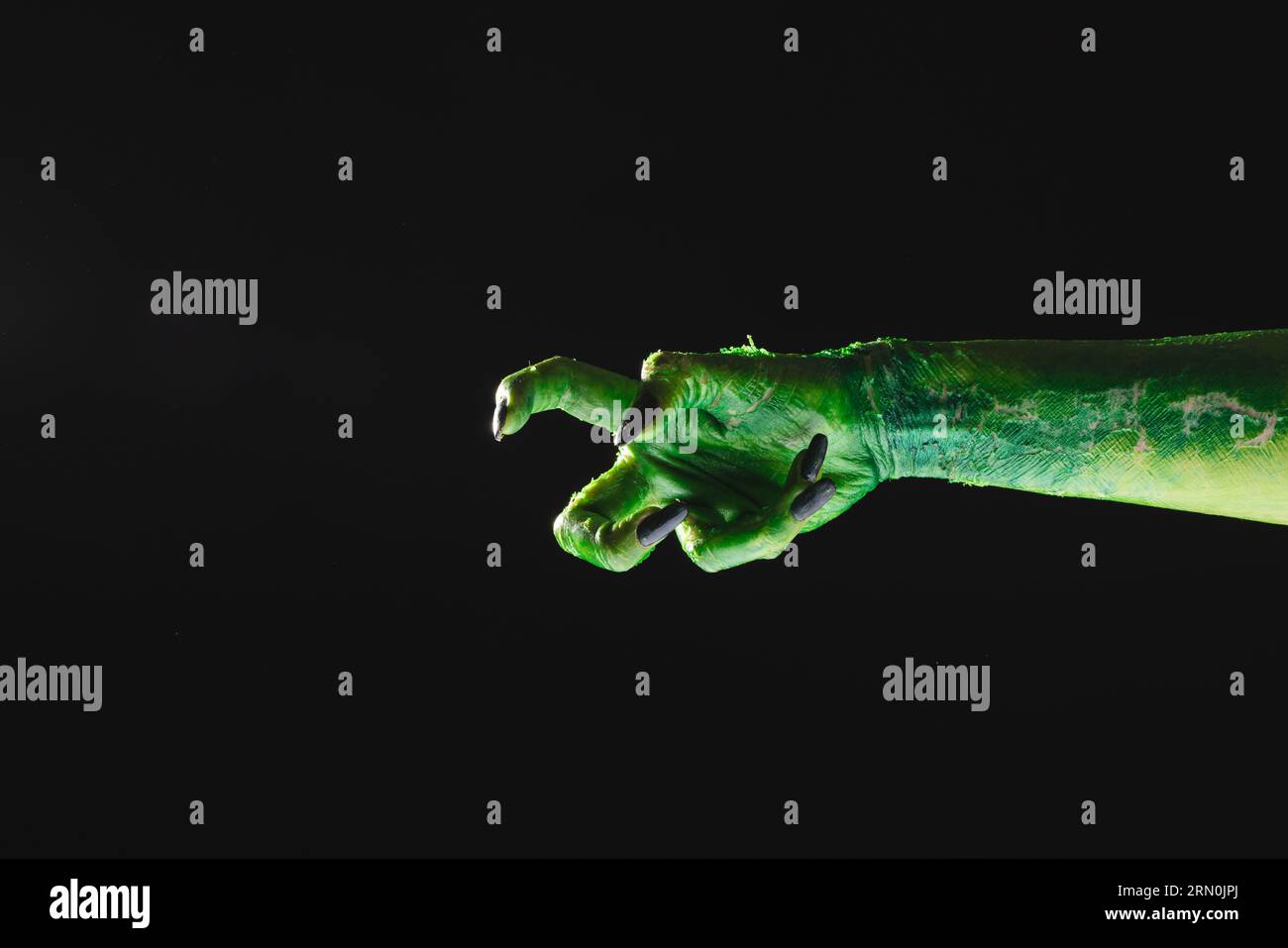 Green monster hand with black nails reaching on black background Stock ...