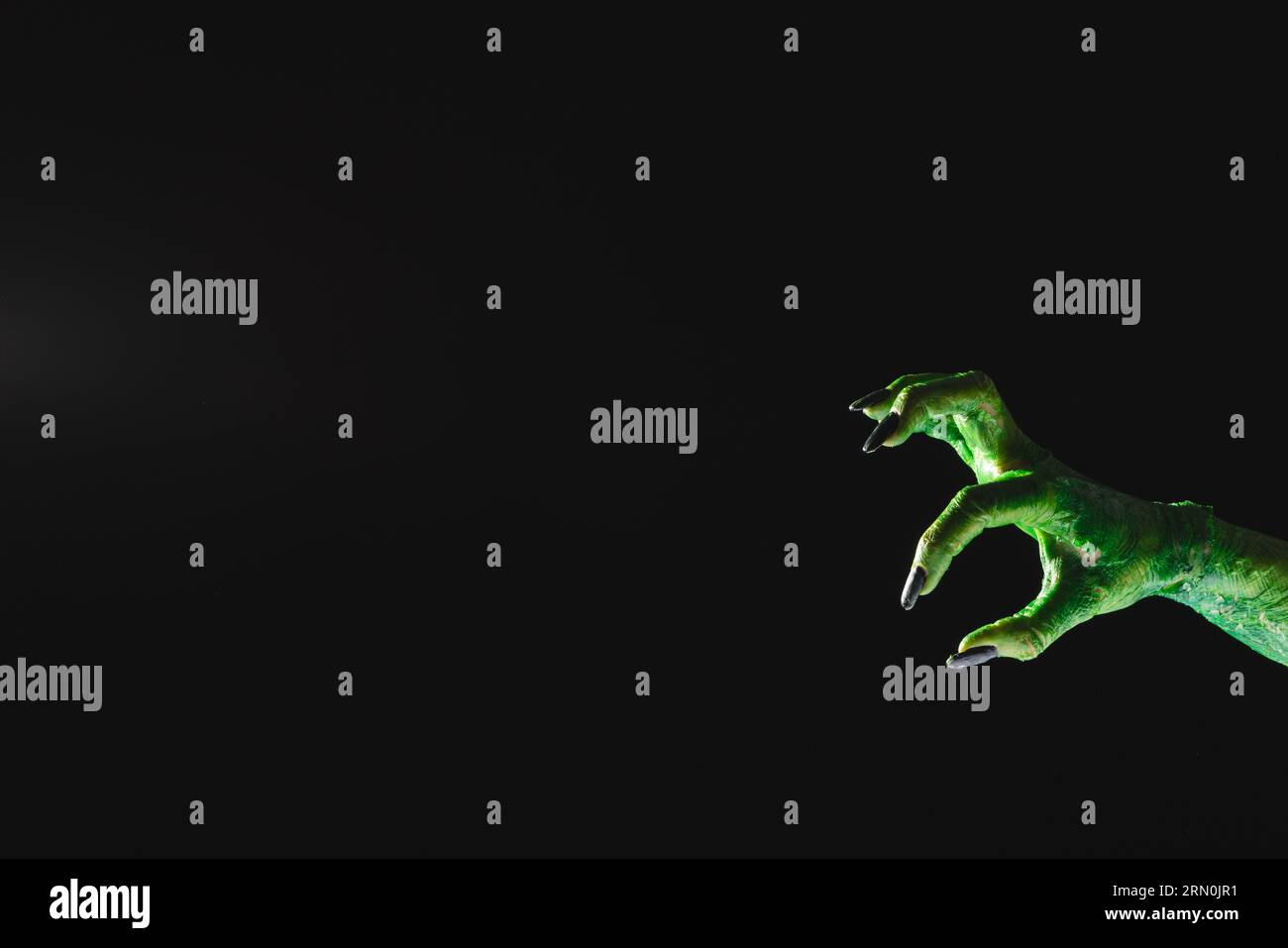 Green monster hand with black nails reaching on black background Stock ...