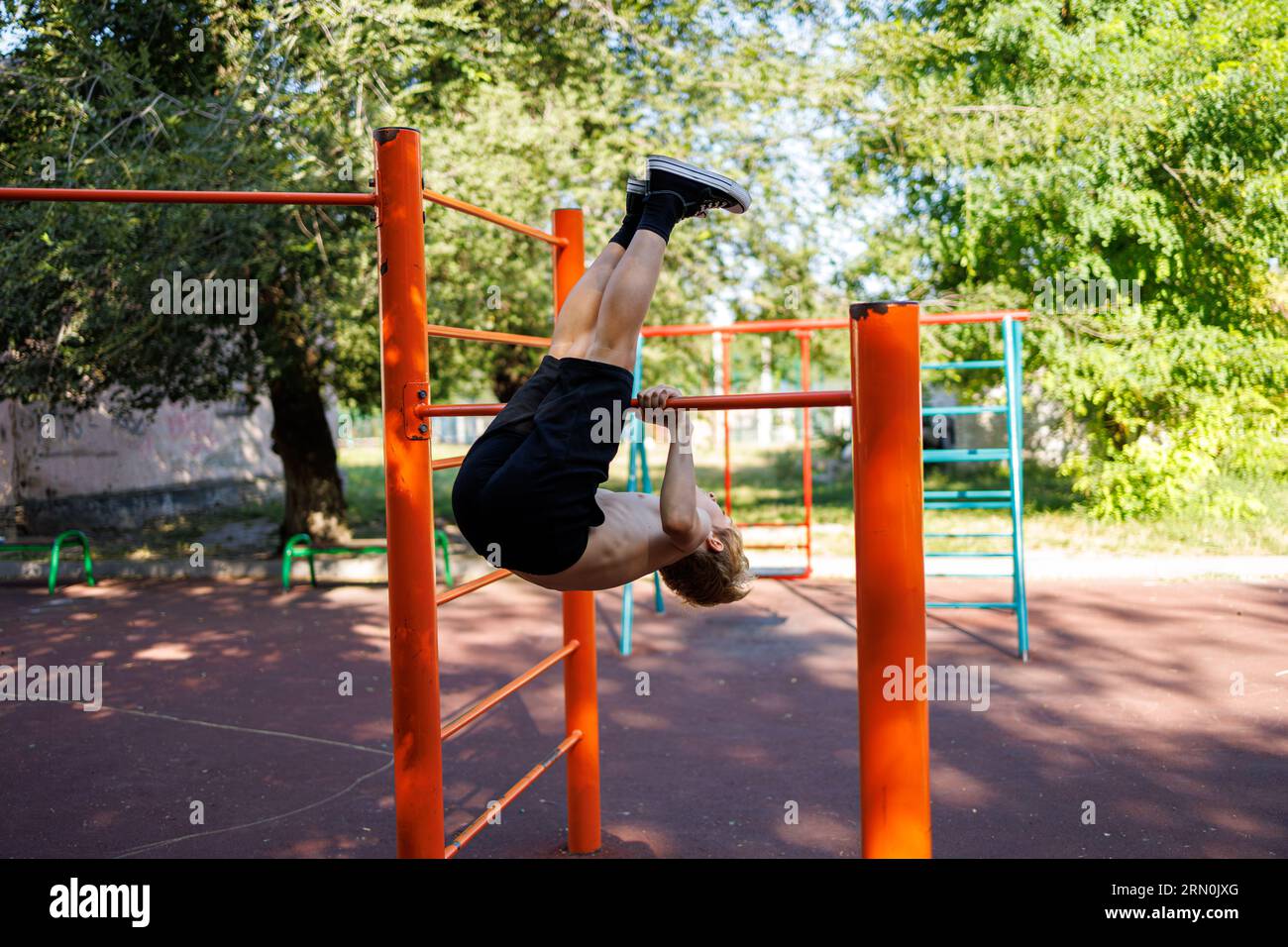 Athletic boy performs exercises on the bar. Street workout on a ...