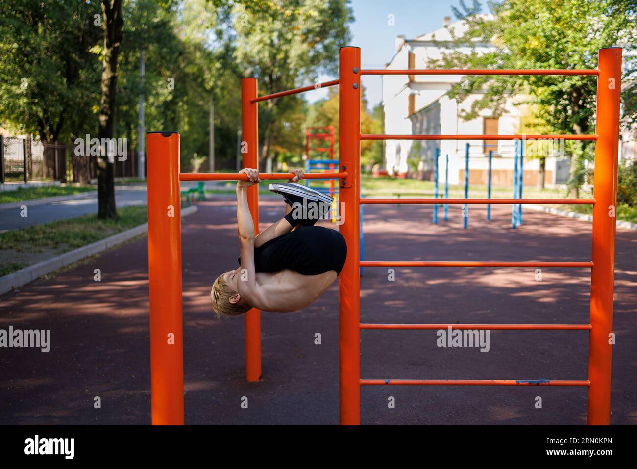 An athletically built teenager is swinging in different directions ...