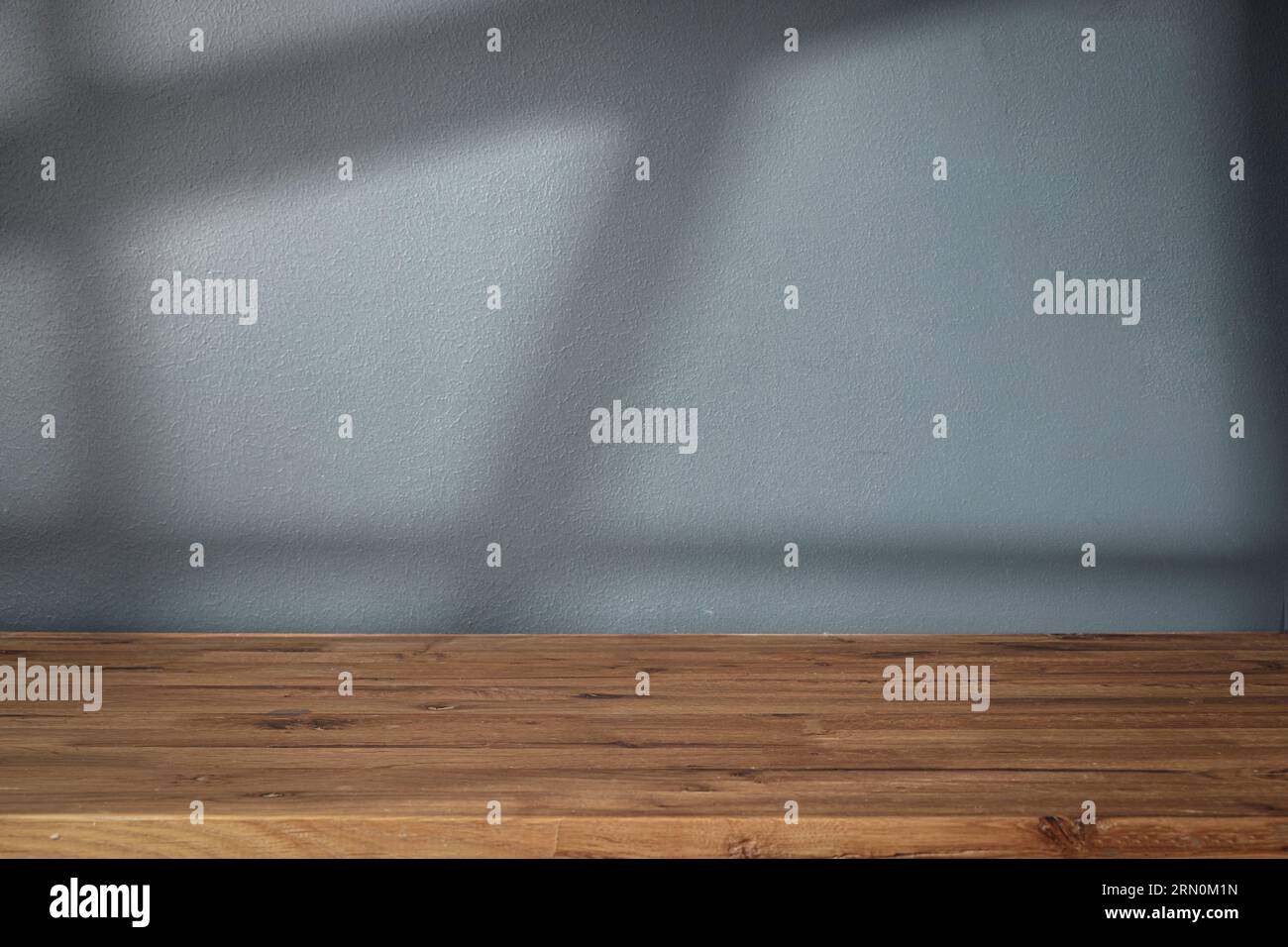 Table shadow background. Wooden table and white empty wall with plant ...